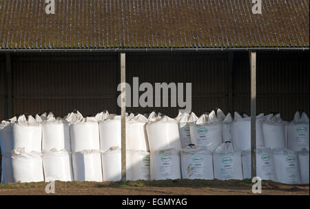 Large chemical fertilizer bags for agricultural use lying beside field ...