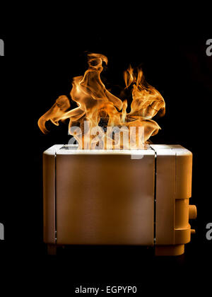 Burning toaster. Toaster with two slices of toast caught on fire over ...