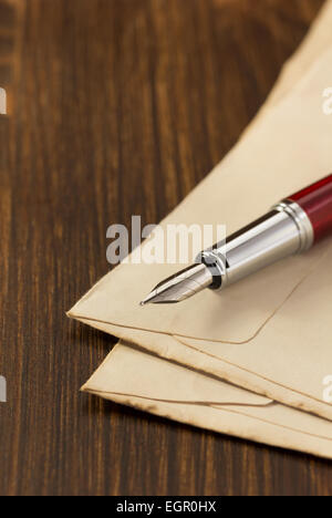 Envelope with pen and ink on wooden background Stock Photo - Alamy