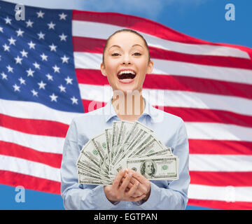 Laughing young woman with USA flag pointing at viewer on orange ...