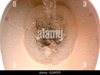 The water flushing inside the toilet bowl in the bathroom and the tiled ...