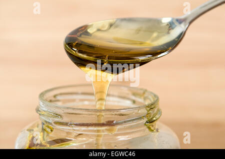 Golden syrup oozing off spoon Stock Photo - Alamy