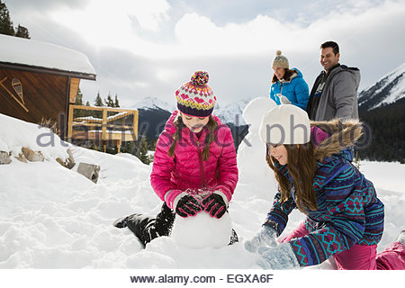 Family making a snowman Stock Photo - Alamy