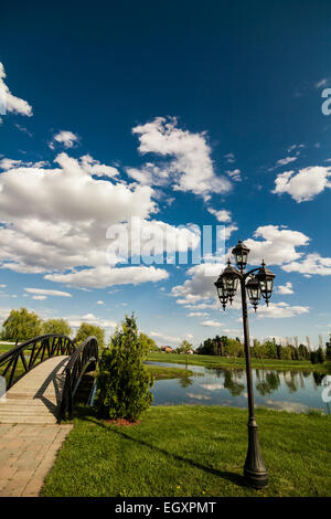 Wooden bridge over little river in city park Stock Photo - Alamy