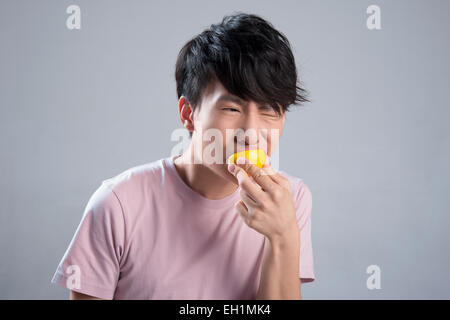 Man biting a slice of lemon Stock Photo - Alamy