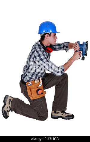 Determined tradesman using a power tool Stock Photo - Alamy
