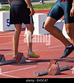 Two runners race on a red track and field athletic track with lane ...