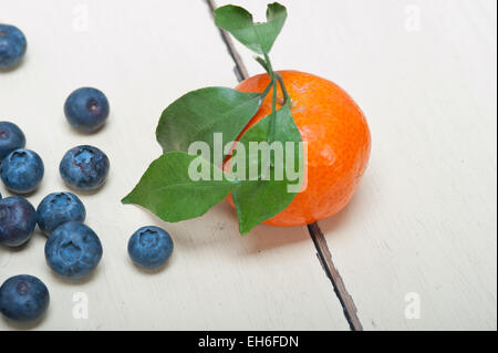 Tangerine and blueberry on white rustic wood table Stock Photo - Alamy