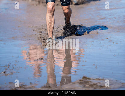 Man running in mud puddle Stock Photo - Alamy