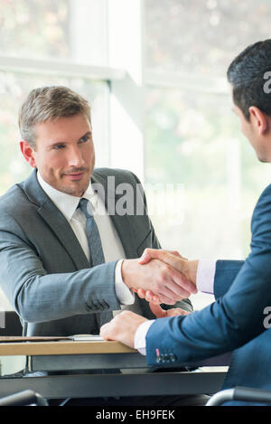 Two Businessmen Shaking Hand in Back Lit Stock Photo - Alamy