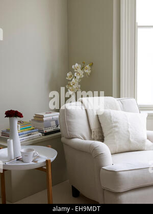 Armchair with cushions, side table, books and decor isolated on white ...