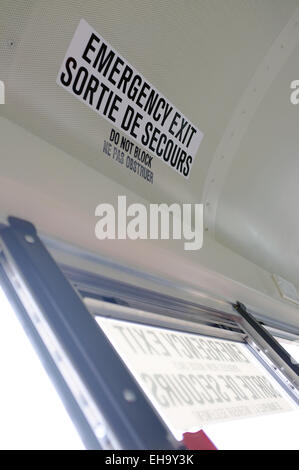 An emergency exit sign in English and French on the roof of a Stock ...