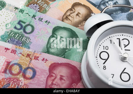 Alarm clock and yuan, time is money Stock Photo - Alamy