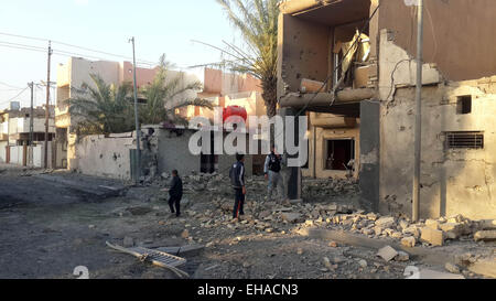 Fallujah, Iraq. 10th Mar, 2015. A man walks by a destroyed building ...