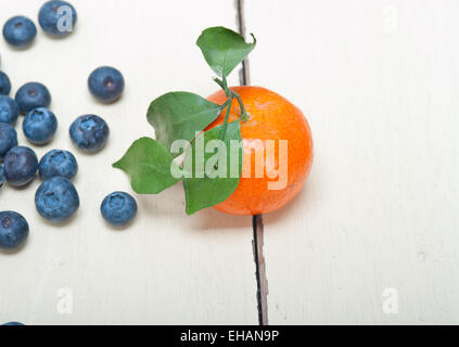 Tangerine and blueberry on white rustic wood table Stock Photo - Alamy