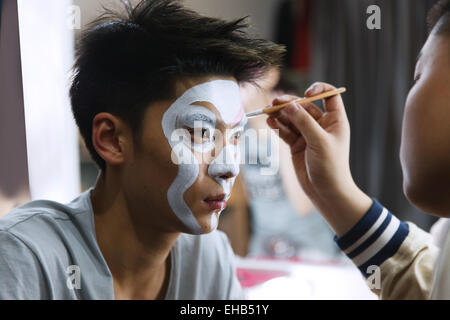 A Peking Opera actor applying makeup, Liyuan Theatre, Beijing, China ...