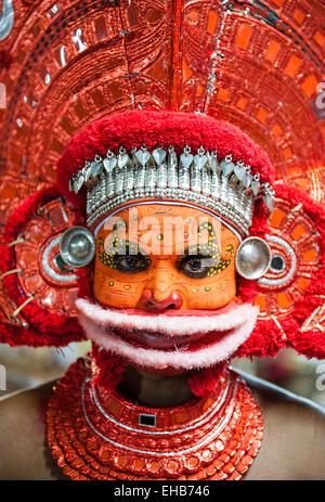 A Theyyam artist in full face make-up and ceremonial costume during a ...