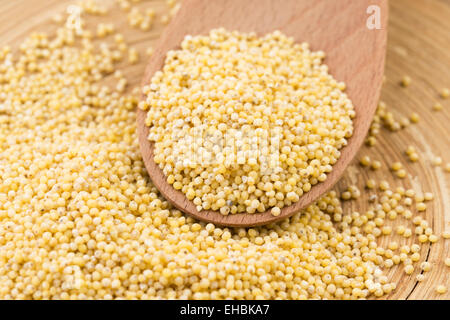 Millet groats with wooden spoon on paper Stock Photo - Alamy