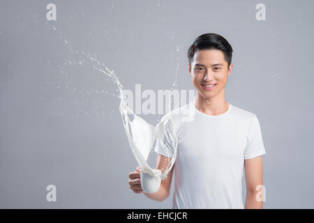 Young man with splashing milk Stock Photo - Alamy