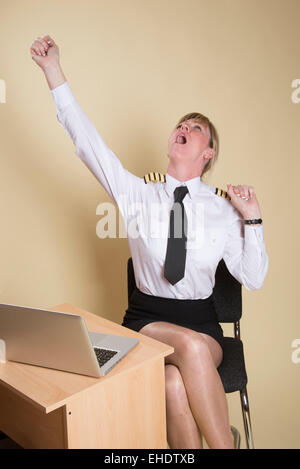 Tired female airline pilot wearing insignia of a captain yawning at end ...