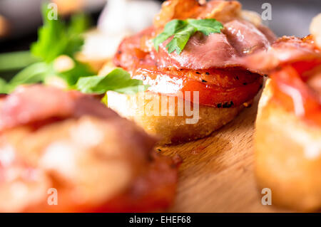 Tapas with fried bacon, tomato and spices Stock Photo - Alamy