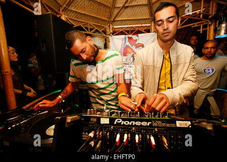 Two DJs are mixing music on console. Art. People are setting up music ...