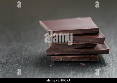 Stack of thin square pieces of chocolate isolated on white background ...