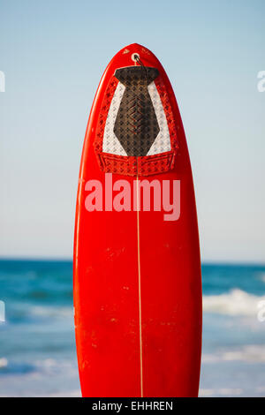 Red surfboard on the sand on a very beautiful sunny day Stock Photo - Alamy