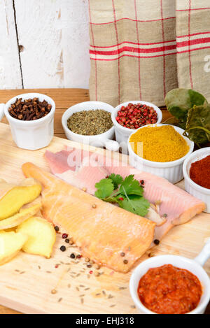 fish fillets with several spices on wooden table Stock Photo - Alamy
