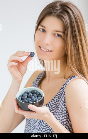 Woman eating blueberries Stock Photo - Alamy