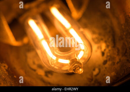 glowing filament of a 1000 quartz halogen bulb with flaked metal and ...