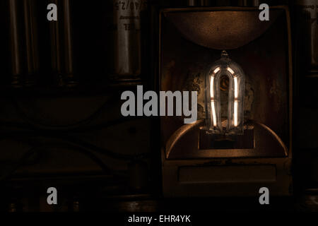 glowing filament of a 1000 quartz halogen bulb with flaked metal and ...