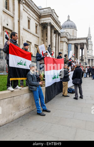 Iraqi protesters rally with their national flag over them in Tahrir ...