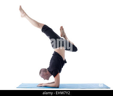 Flexible man posing in difficult yoga pose Stock Photo - Alamy