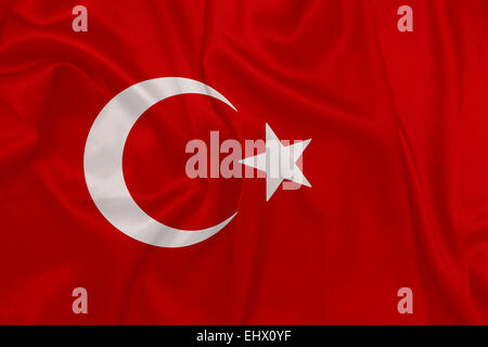 The Turkish national flag waving on a flagpole over the blue waters of ...