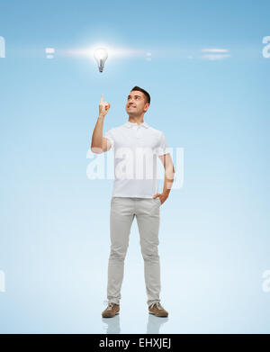 Businessman pointing at light bulb with business sketches at background ...