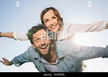Happy couple with outstretched arms at backlight Stock Photo - Alamy
