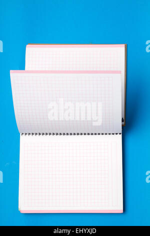 Small notebook over a blue background Stock Photo - Alamy