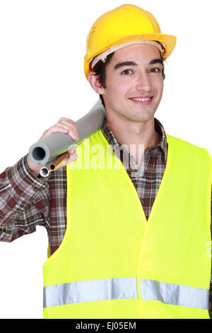 Construction worker carrying tubes Stock Photo - Alamy