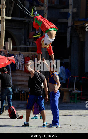 Urban night scene shows a busy street with parked scooters, lighted ...