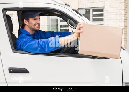 Delivery driver offering parcel from his van Stock Photo - Alamy