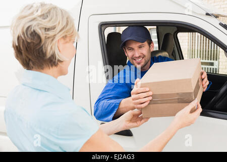 Delivery driver handing parcel to customer in his van Stock Photo - Alamy