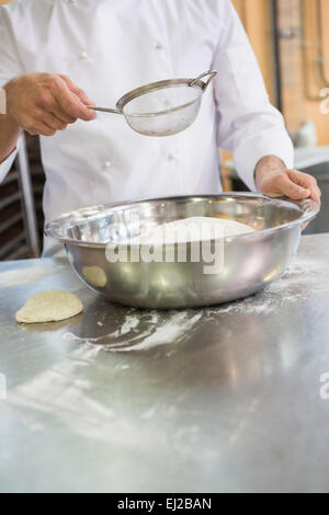 Baker working with sieve and bowl Stock Photo - Alamy