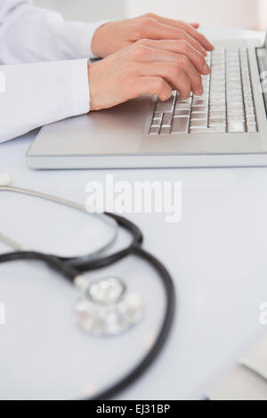 Doctor Using Laptop With Stethoscope On Desk Stock Photo - Alamy