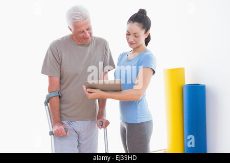 Senior man with coach looking at clipboard Stock Photo - Alamy