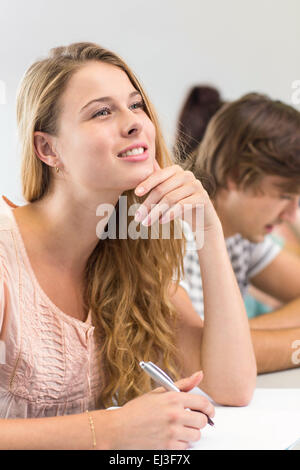 Male student writing notes in classroom Stock Photo - Alamy