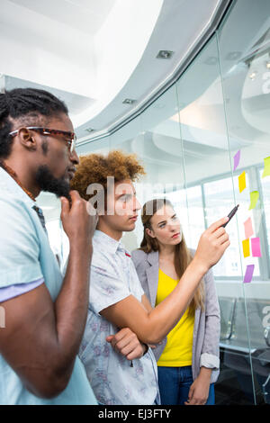 Creative team pointing at adhesive notes Stock Photo - Alamy