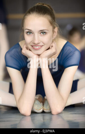 Young adult female ballerina with brown hair in black attire strikes ...