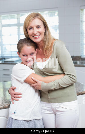 beautiful happy mother and daughter hugging and looking at window Stock Photo - Alamy