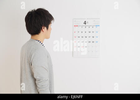 Young Japanese man looking at the calendar Stock Photo - Alamy